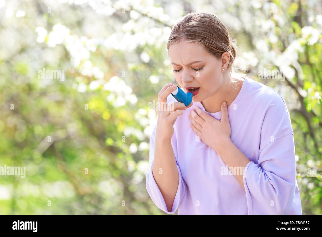 Woman with inhaler having asthma attack on spring day Stock Photo - Alamy