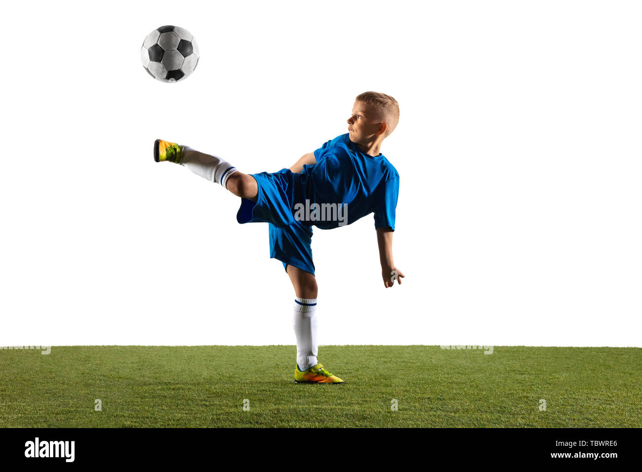 Young boy as a soccer or football player in sportwear making a feint or ...