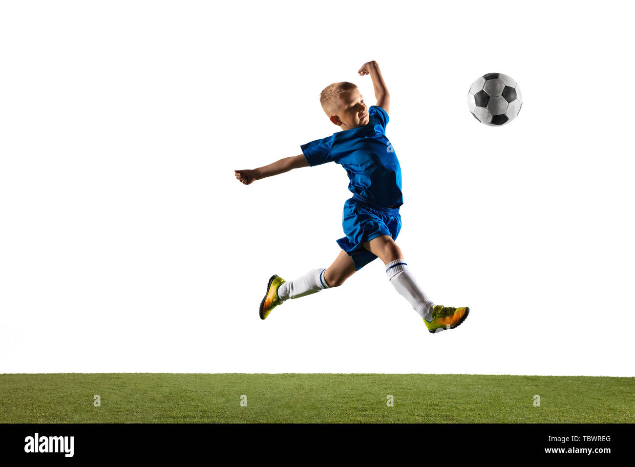 Young boy as a soccer or football player in sportwear making a feint or ...