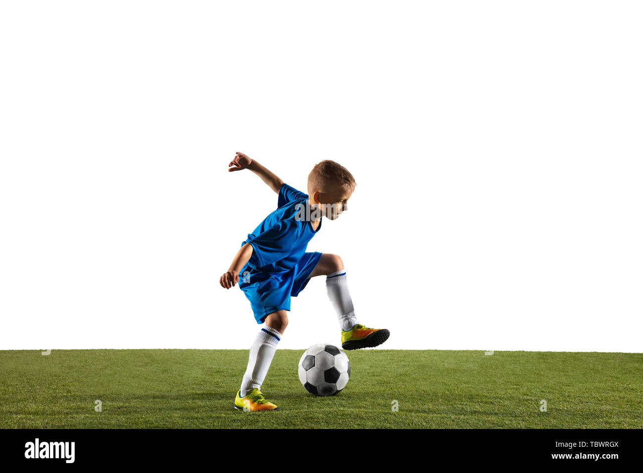 Young boy as a soccer or football player in sportwear making a feint or ...