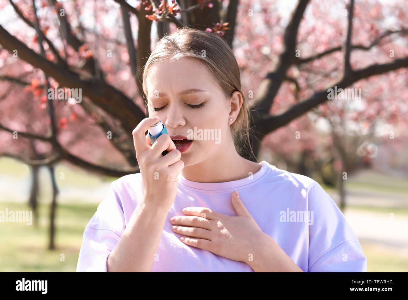 Woman with inhaler having asthma attack on spring day Stock Photo - Alamy