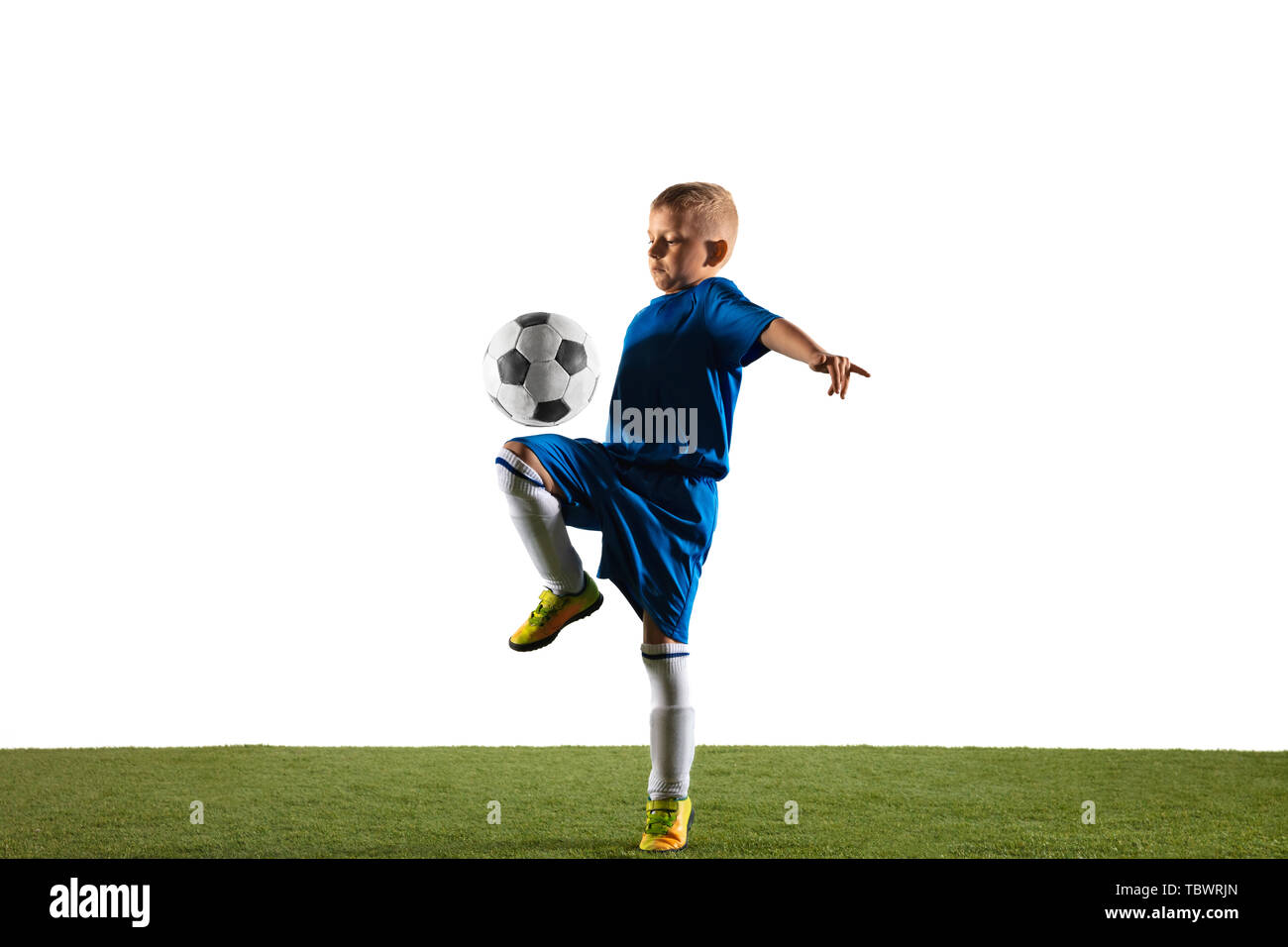 Young boy as a soccer or football player in sportwear making a feint or ...