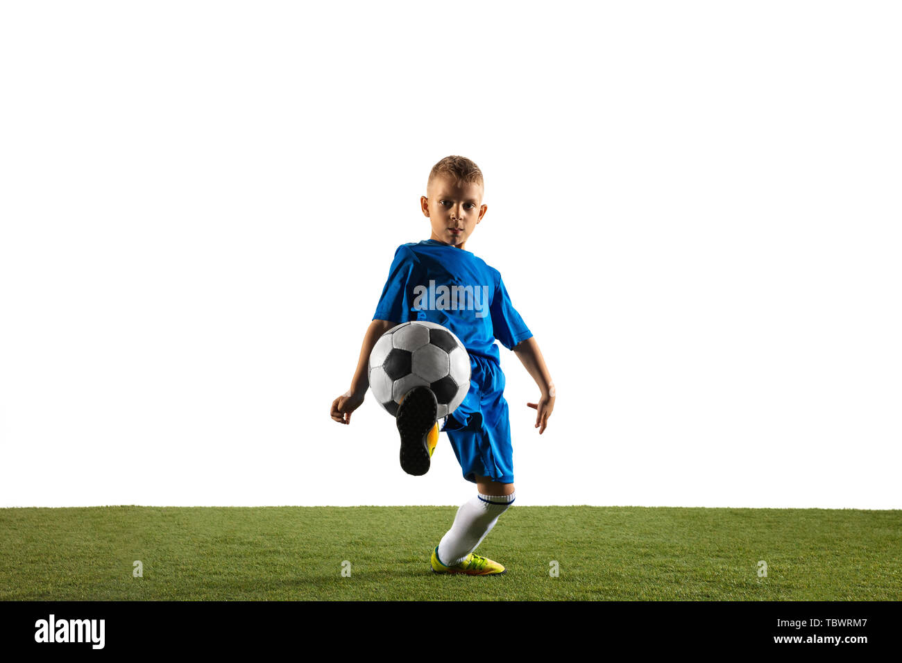 Young boy as a soccer or football player in sportwear making a feint or ...