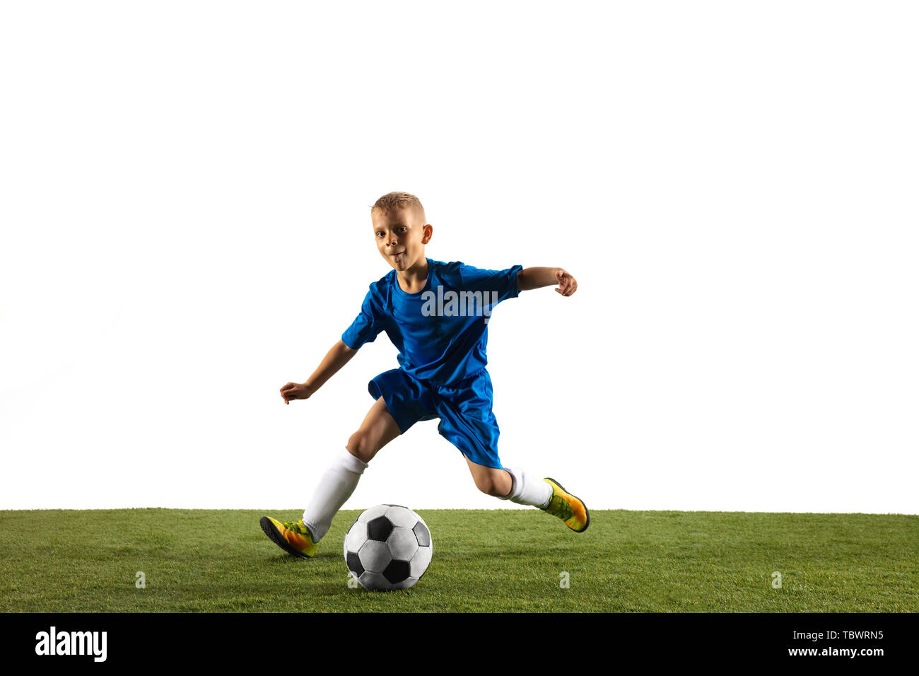 Young boy as a soccer or football player in sportwear making a feint or ...