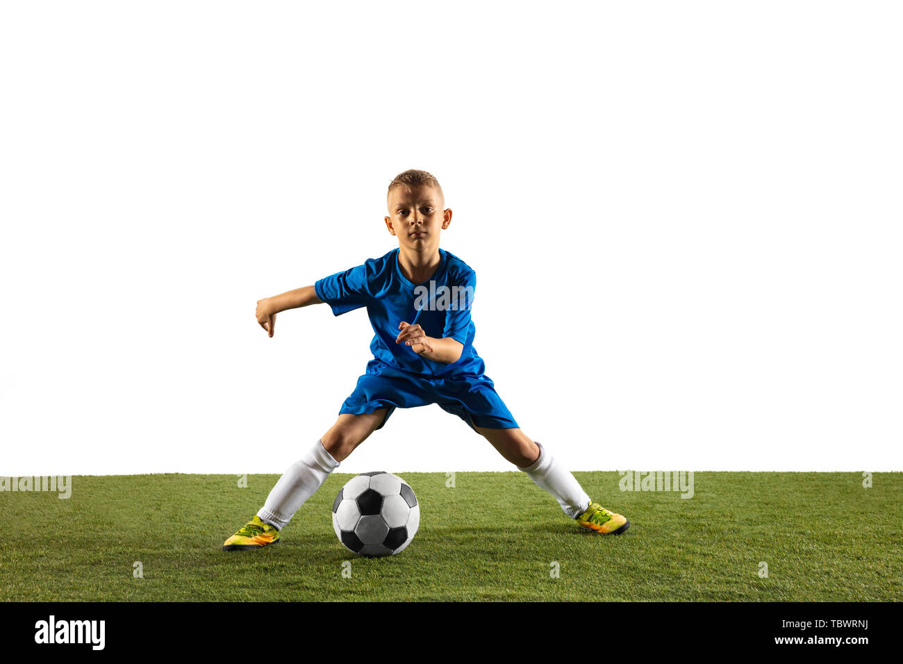 Young boy as a soccer or football player in sportwear making a feint or ...