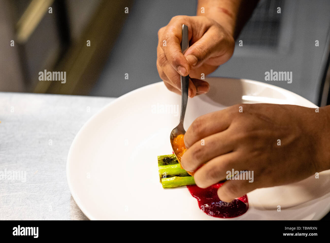 Close up of skilled professional chef hands plating healthy and ...