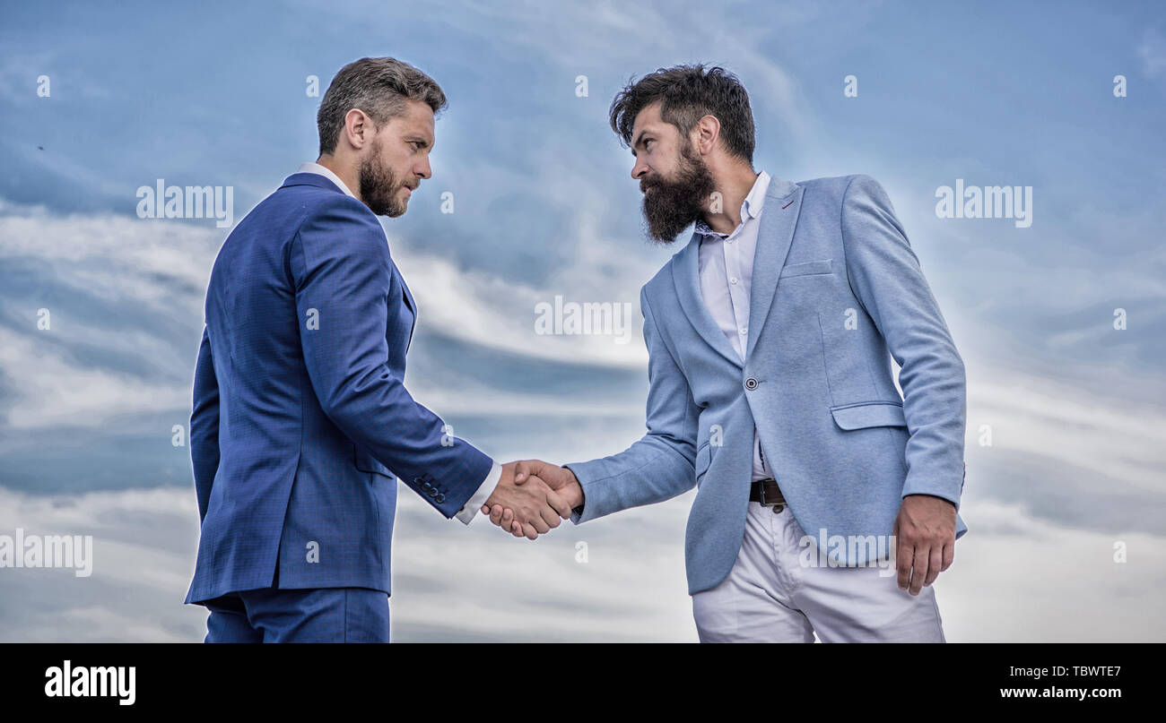 Sure sign you should trust business partner. Men formal suits shaking ...