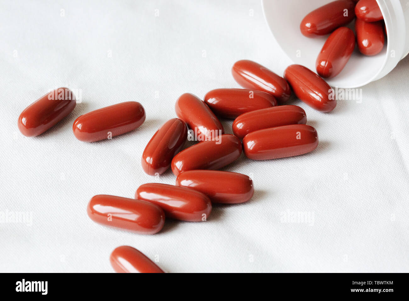 Red pill on white background Stock Photo - Alamy