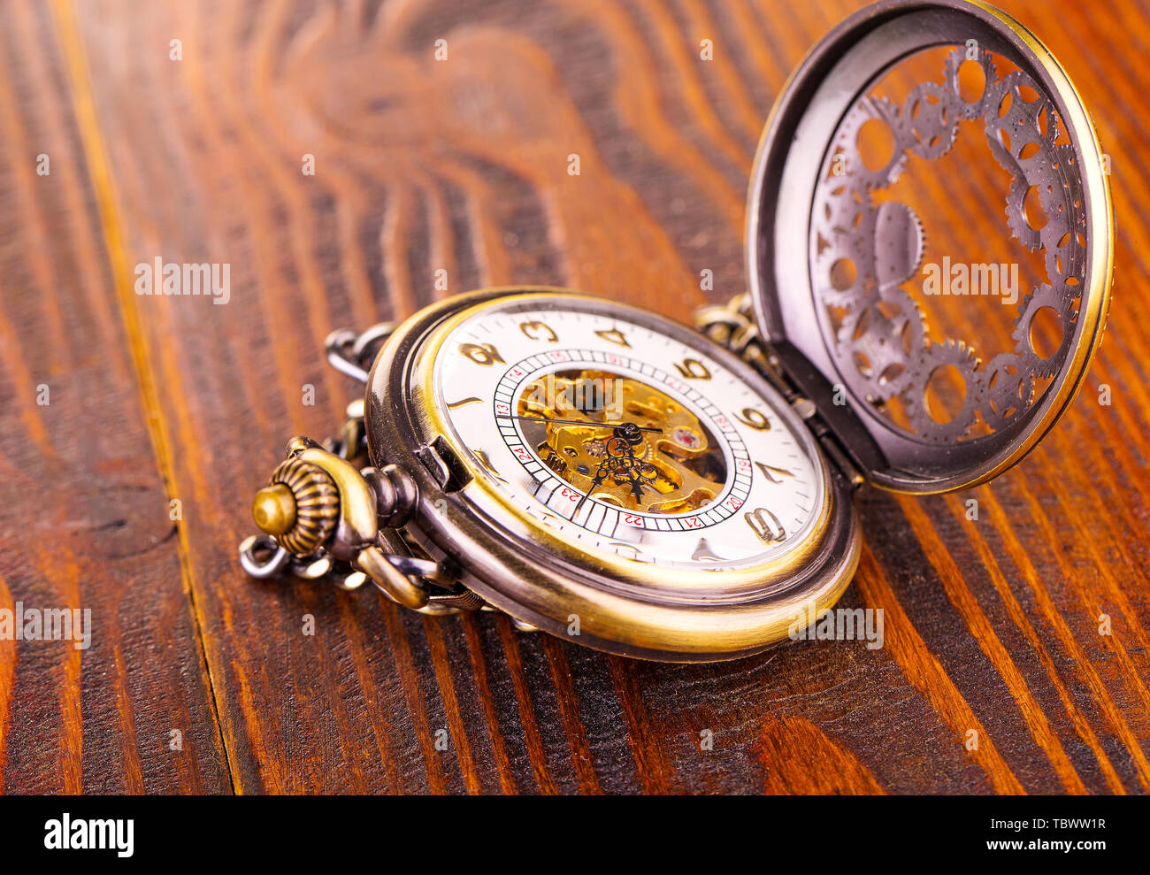 Image of an elegant antique pocket watch, photographed on an old wooden ...