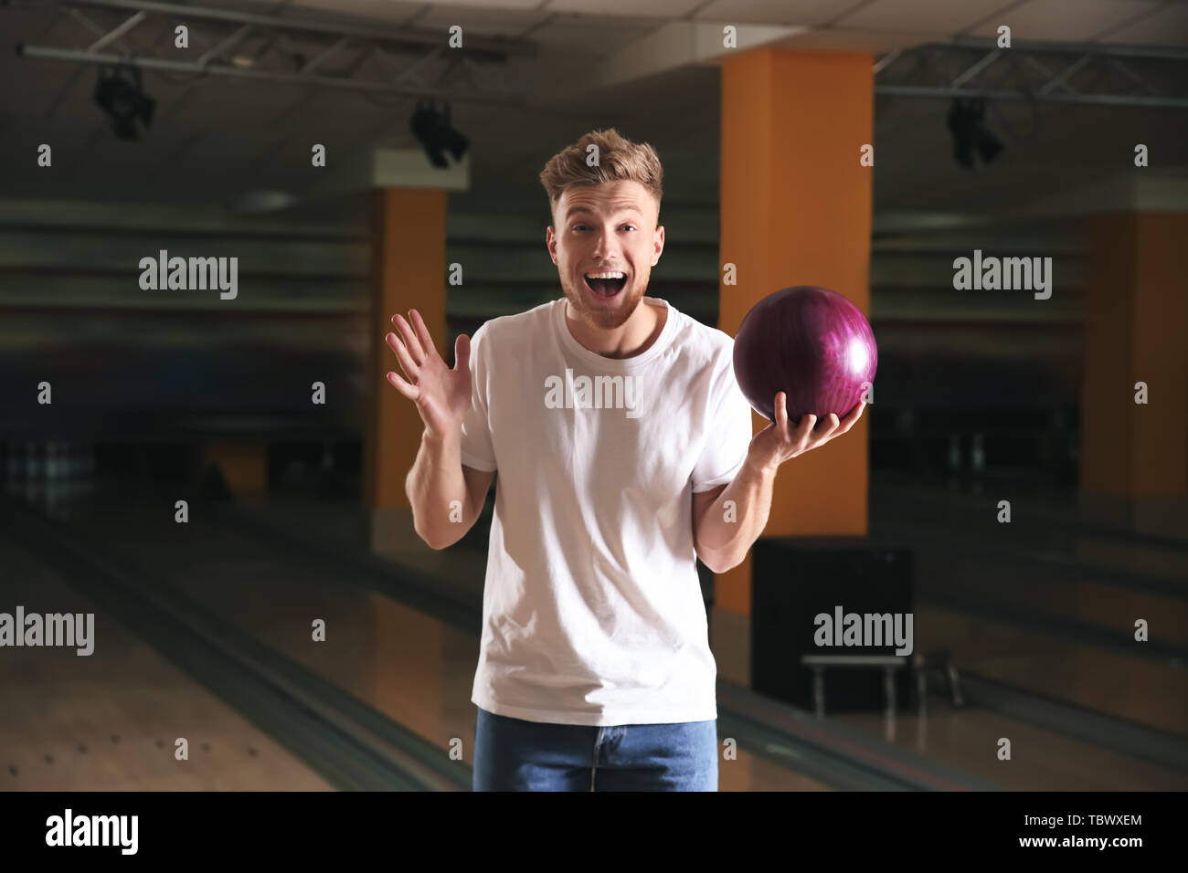 Happy young man in bowling club Stock Photo - Alamy