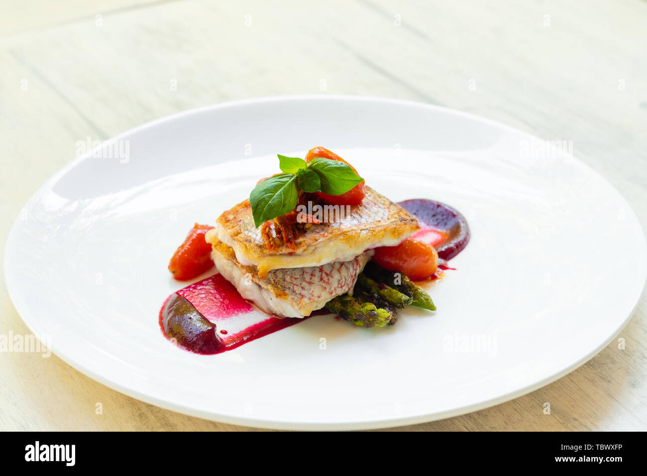 close up of a pan seared grilled red snapper fish fillet with asparagus ...
