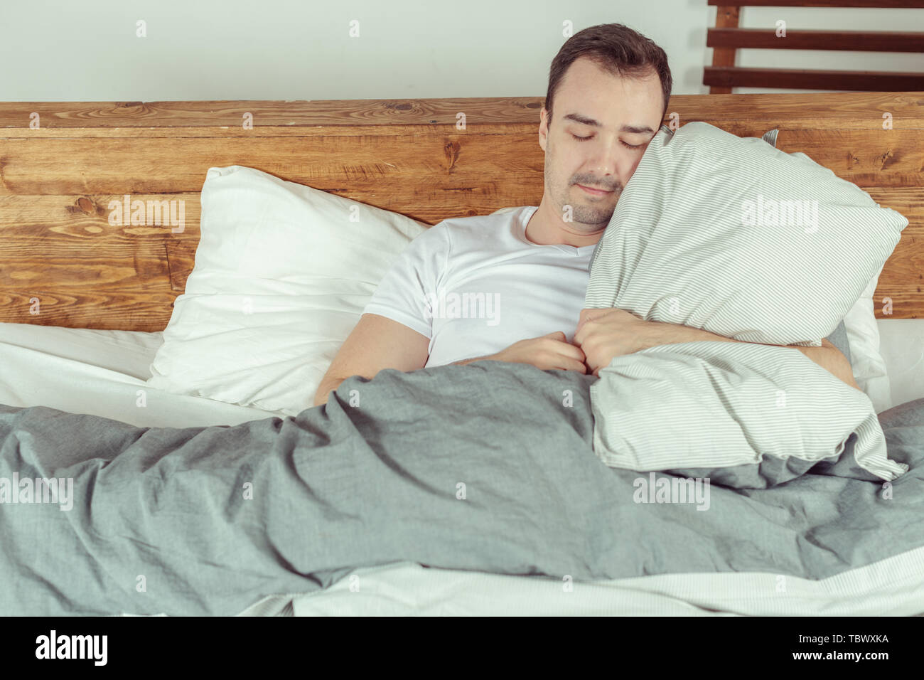 Young Man Sleeping On Bed In Bedroom Stock Photo - Alamy