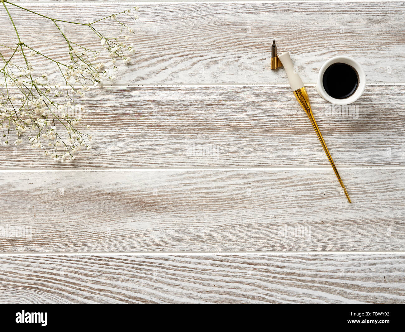 Calligraphy pen and ink on a wooden white table. View from the top ...