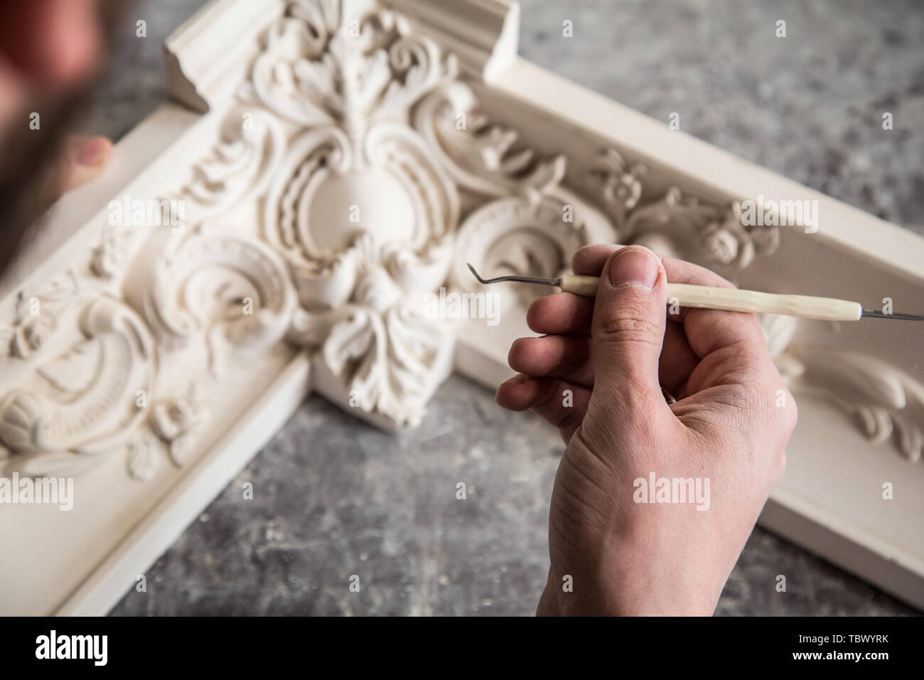 The sculptor creates a bas-relief. Plaster workshop. Close up ...
