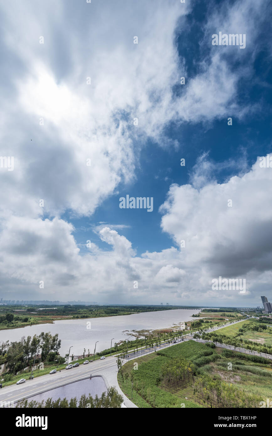 Cloudy weather overlooks riverside green space building Stock Photo - Alamy