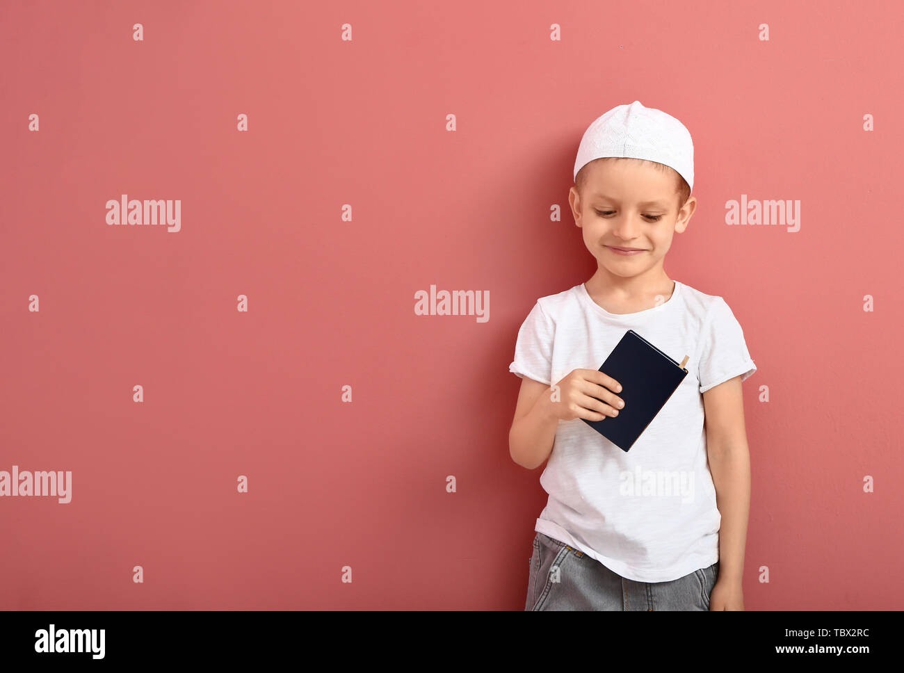 Little Muslim boy with Koran on color background Stock Photo - Alamy