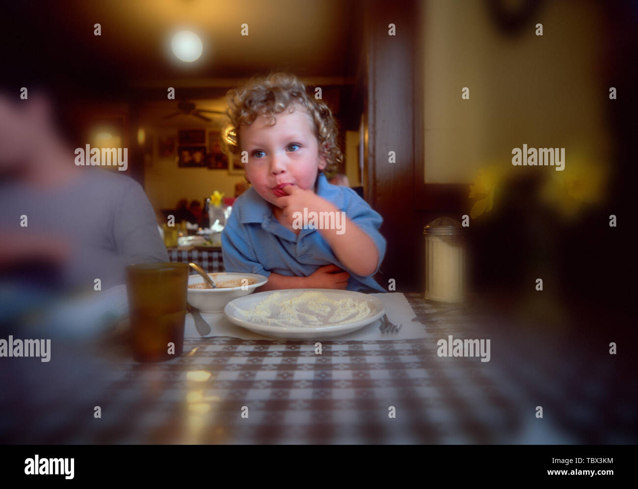A young child is enjoying his meal at a restaurant Stock Photo - Alamy