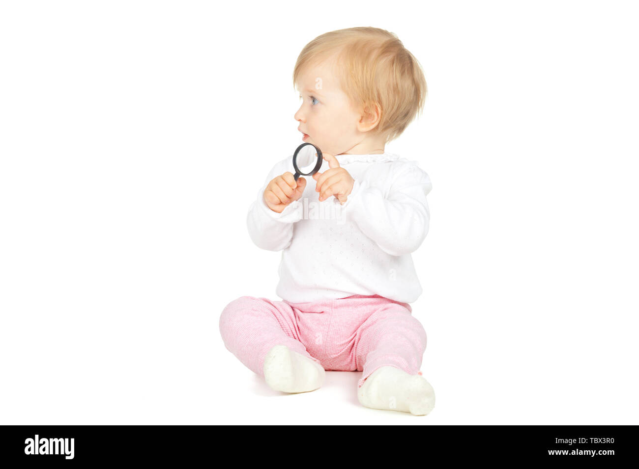 Caucasian baby girl holding magnifying glass isolated on white ...