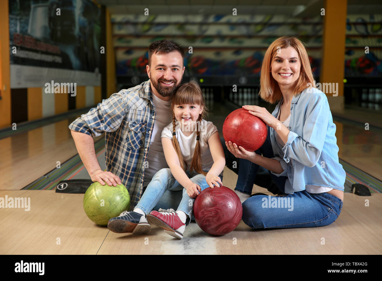 Happy family in bowling club Stock Photo - Alamy