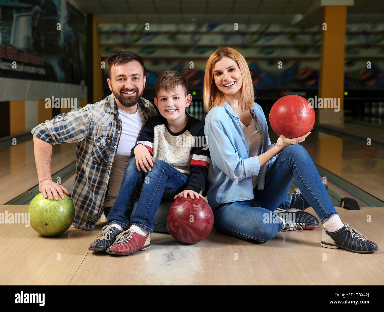 Happy family in bowling club Stock Photo - Alamy