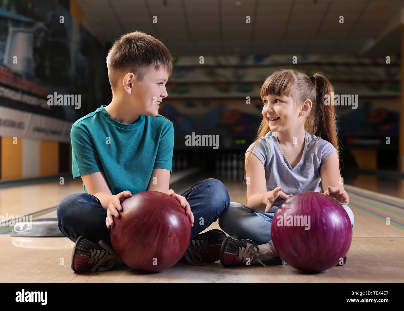 Little children with balls in bowling club Stock Photo - Alamy