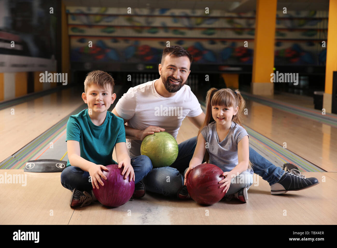 Happy family in bowling club Stock Photo - Alamy