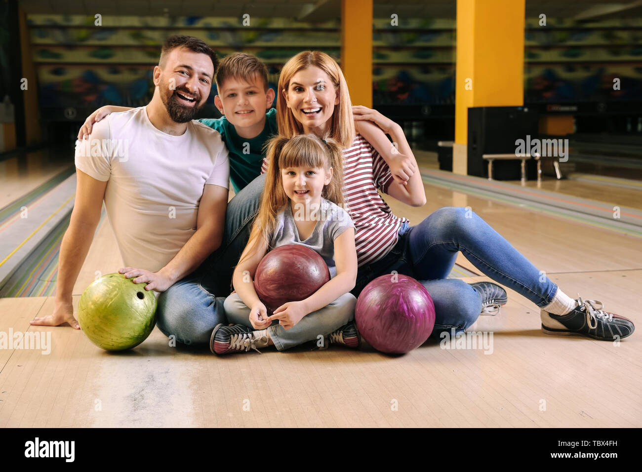 Happy family in bowling club Stock Photo - Alamy