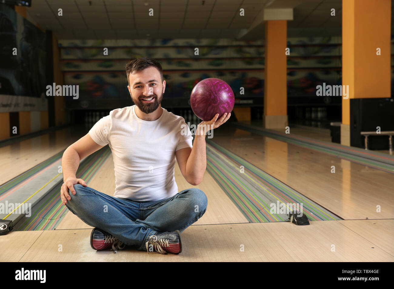 Man with ball in bowling club Stock Photo - Alamy