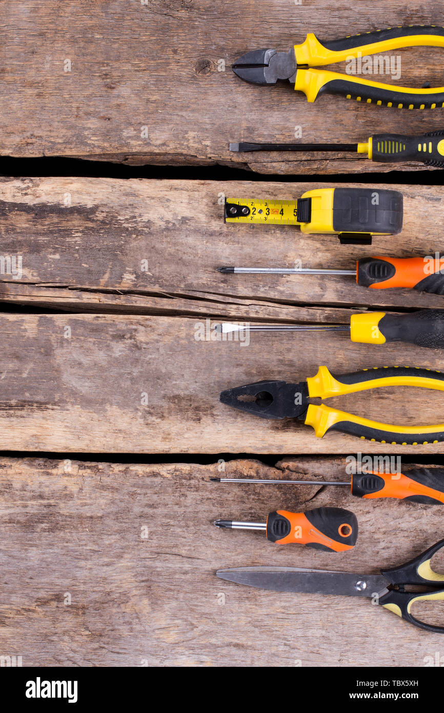 Assorted construction tools on rustic wooden background. Cracked wooden ...