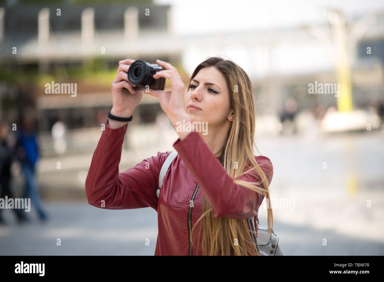 Young woman using a mirrorless camera Stock Photo - Alamy