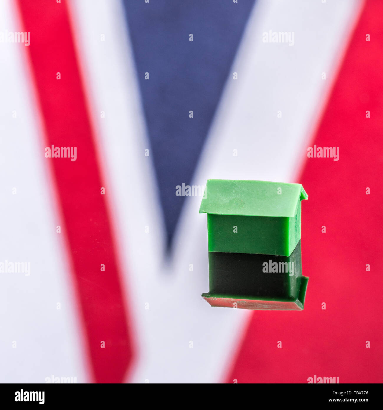 Union Jack with small toy counter. For UK housing crisis, getting on ...