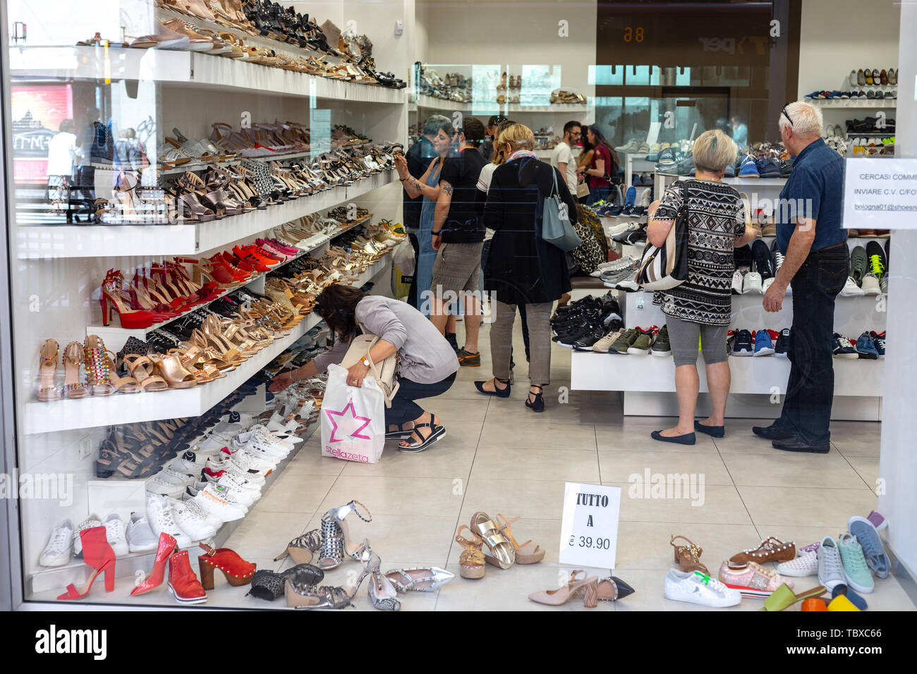 View through window with people and shelves in a shoes shop in Bologna ...