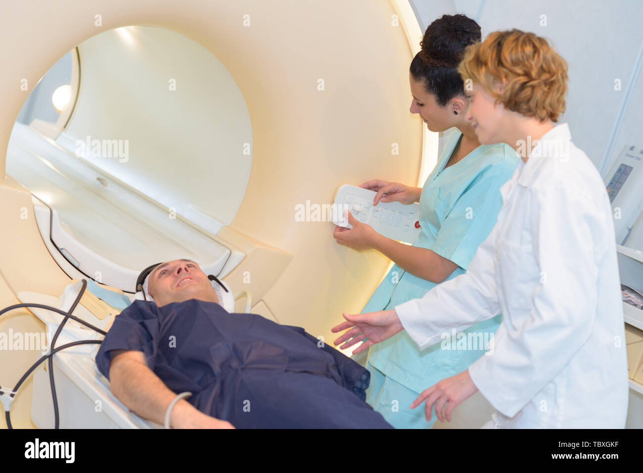 nurses reassuring patient as he enters mri scanner Stock Photo - Alamy