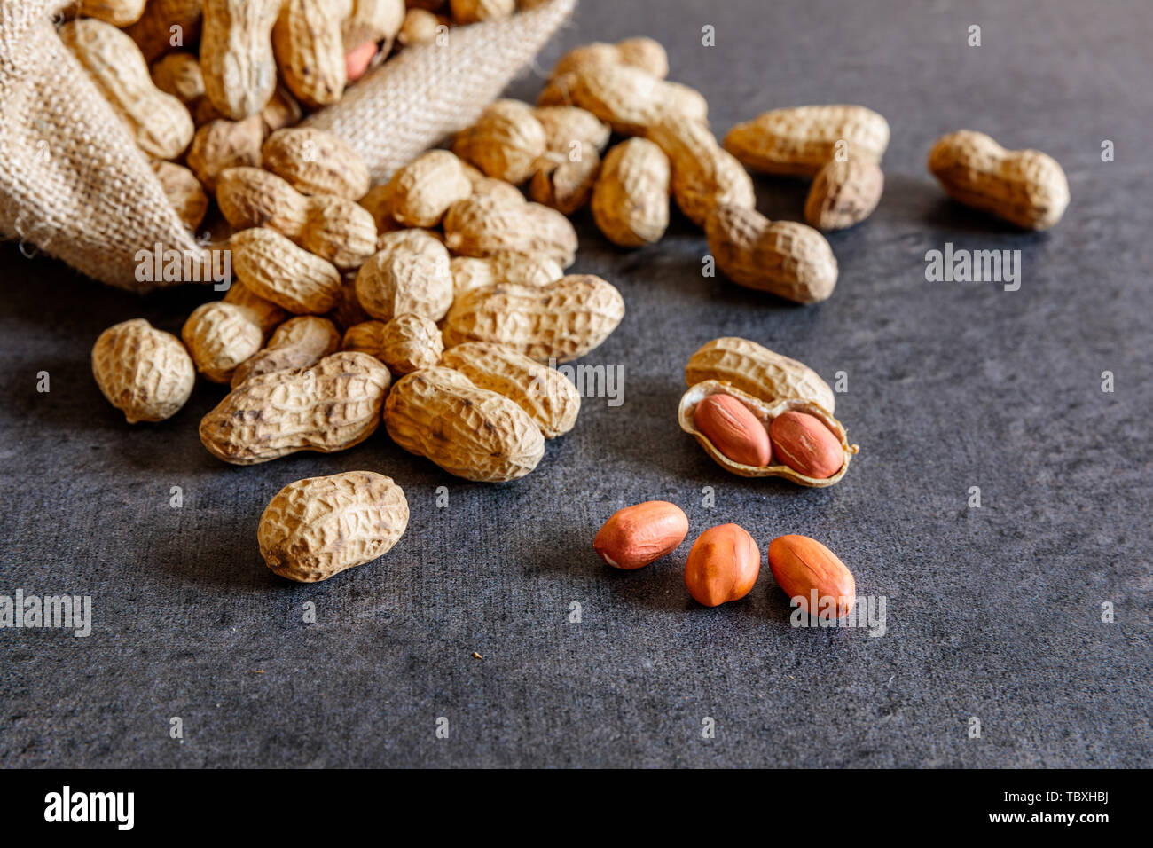 Peanuts poured out of a sack Stock Photo - Alamy