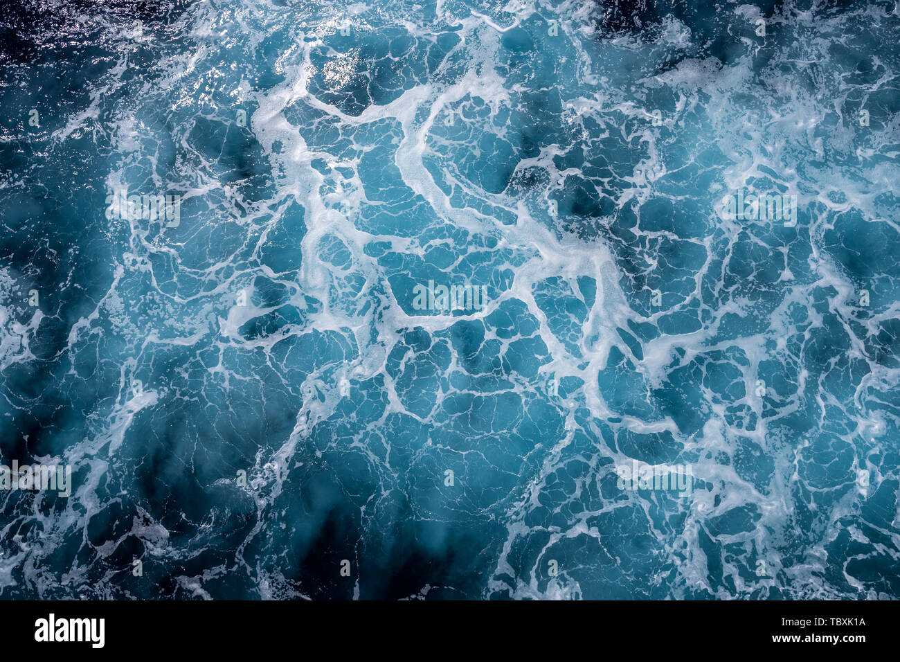 Rough deep turquoise and blue sea with white foam bubbles texture ...