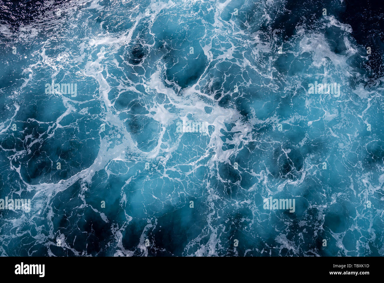 Rough deep turquoise and blue sea with white foam bubbles texture ...