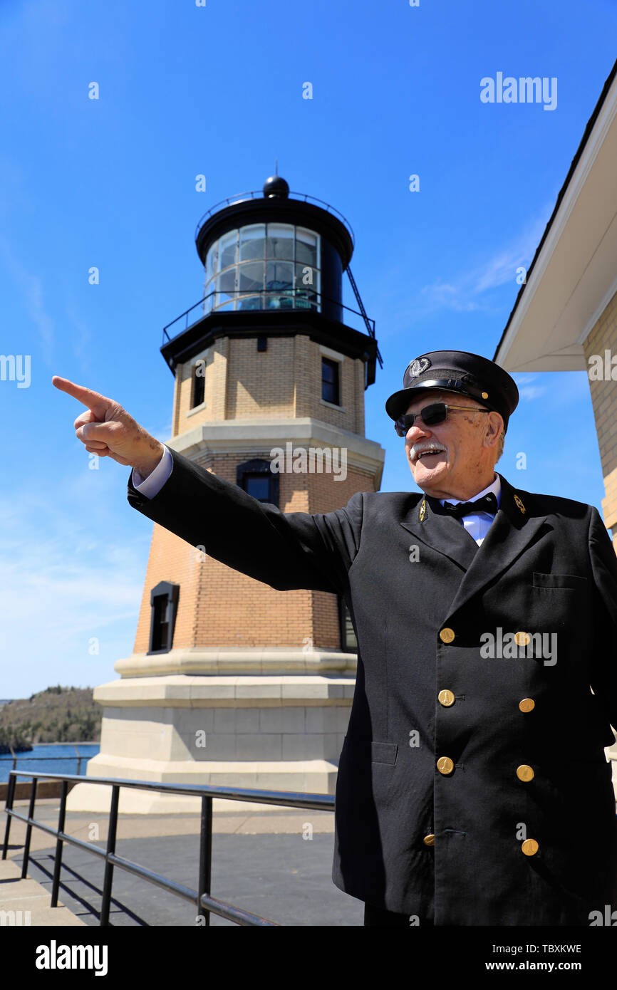 A male guide in traditional lighthouse keepers' uniform posing by the ...
