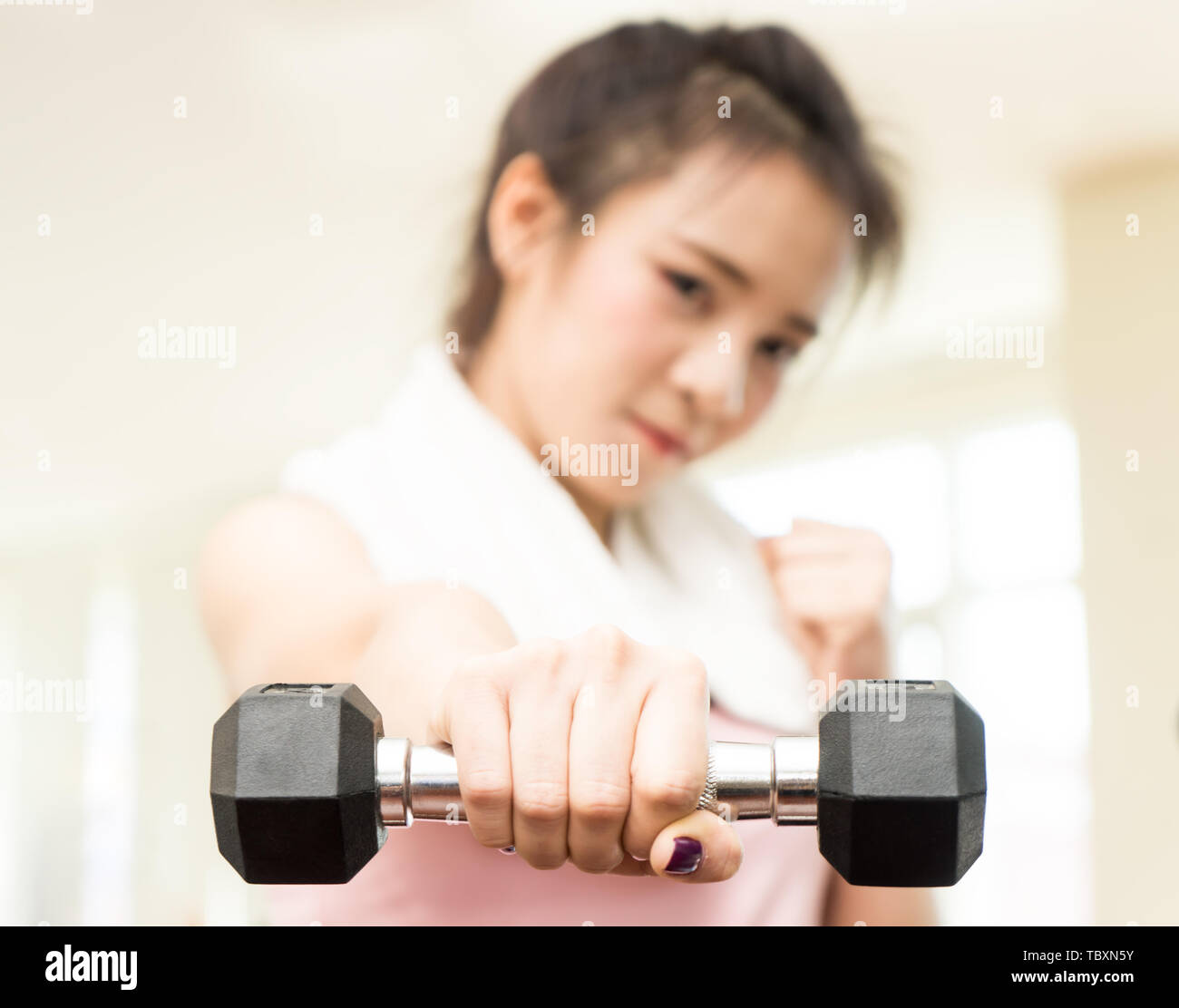 Asian woman is punching the Dumbbell forward in fitness Stock Photo - Alamy