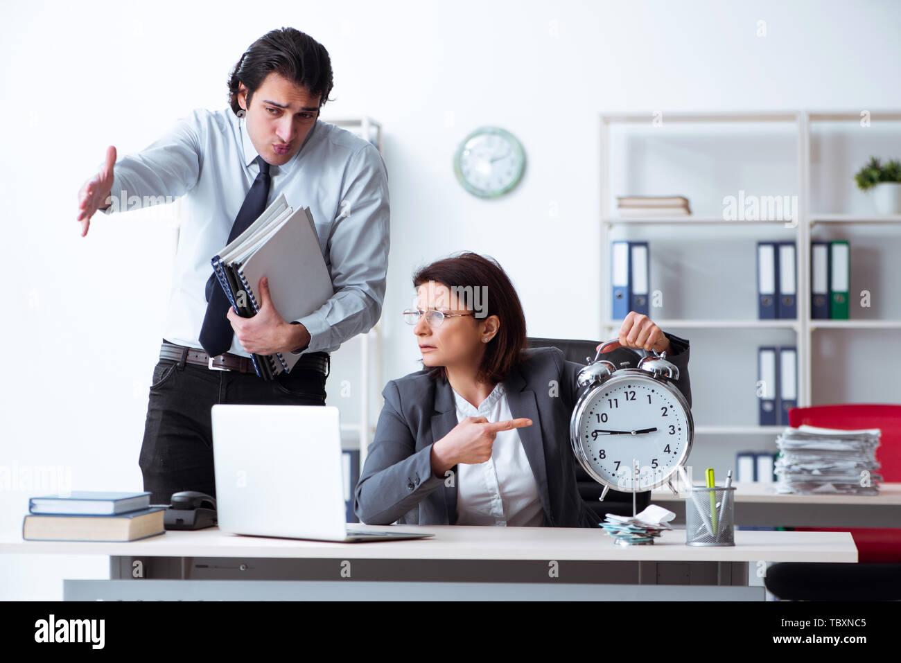 Old female boss and young male employee in the office Stock Photo - Alamy