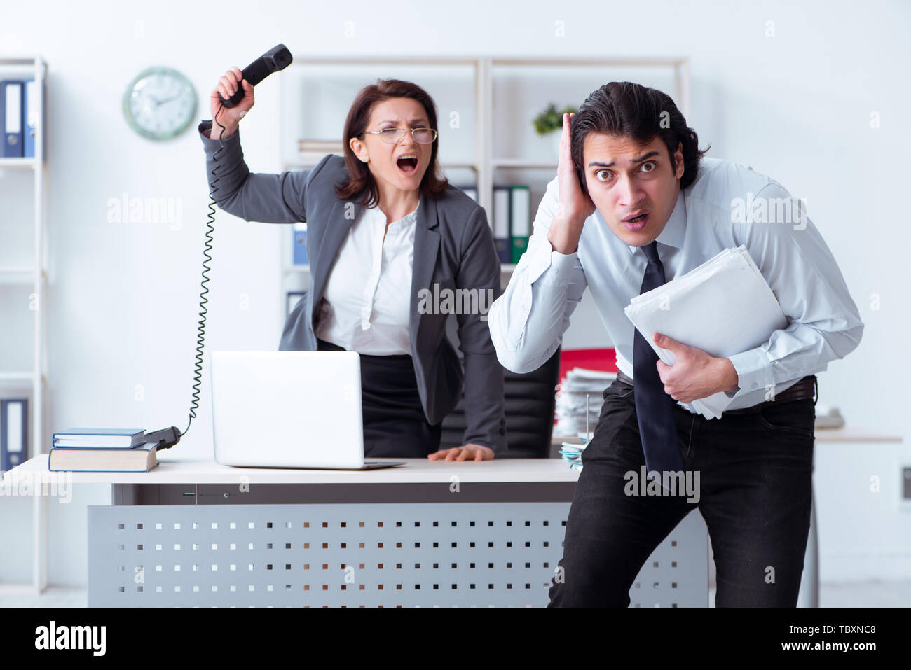Old female boss and young male employee in the office Stock Photo - Alamy