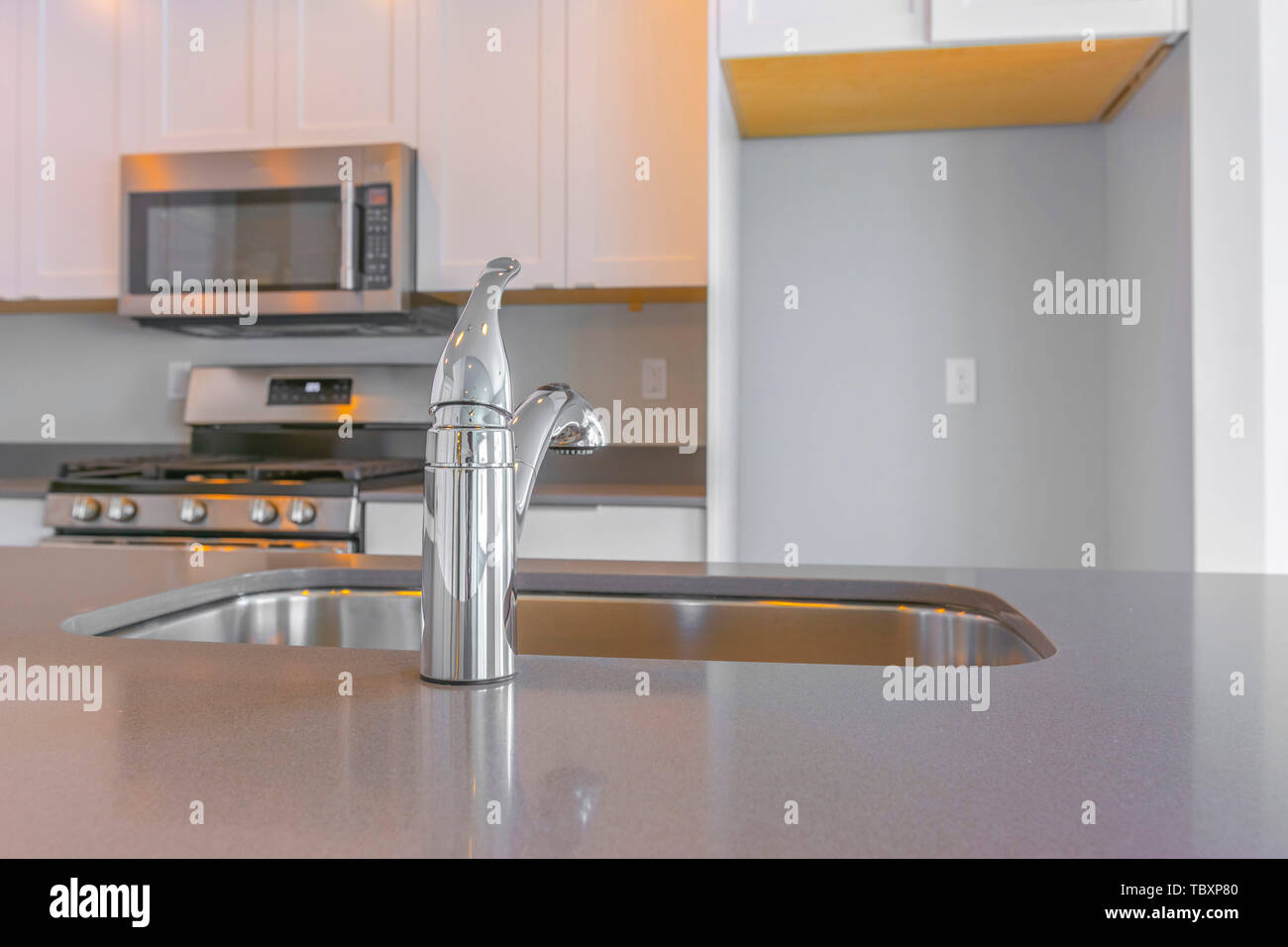 Modern kitchen interior with close up on the shiny faucet and sink ...