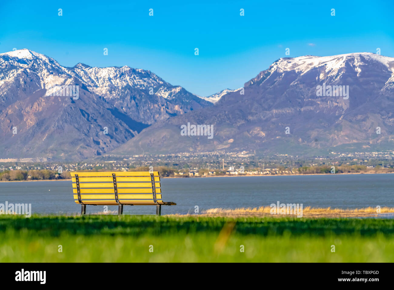 Empty bench facing an amazing view of a lake and mountain capped with ...