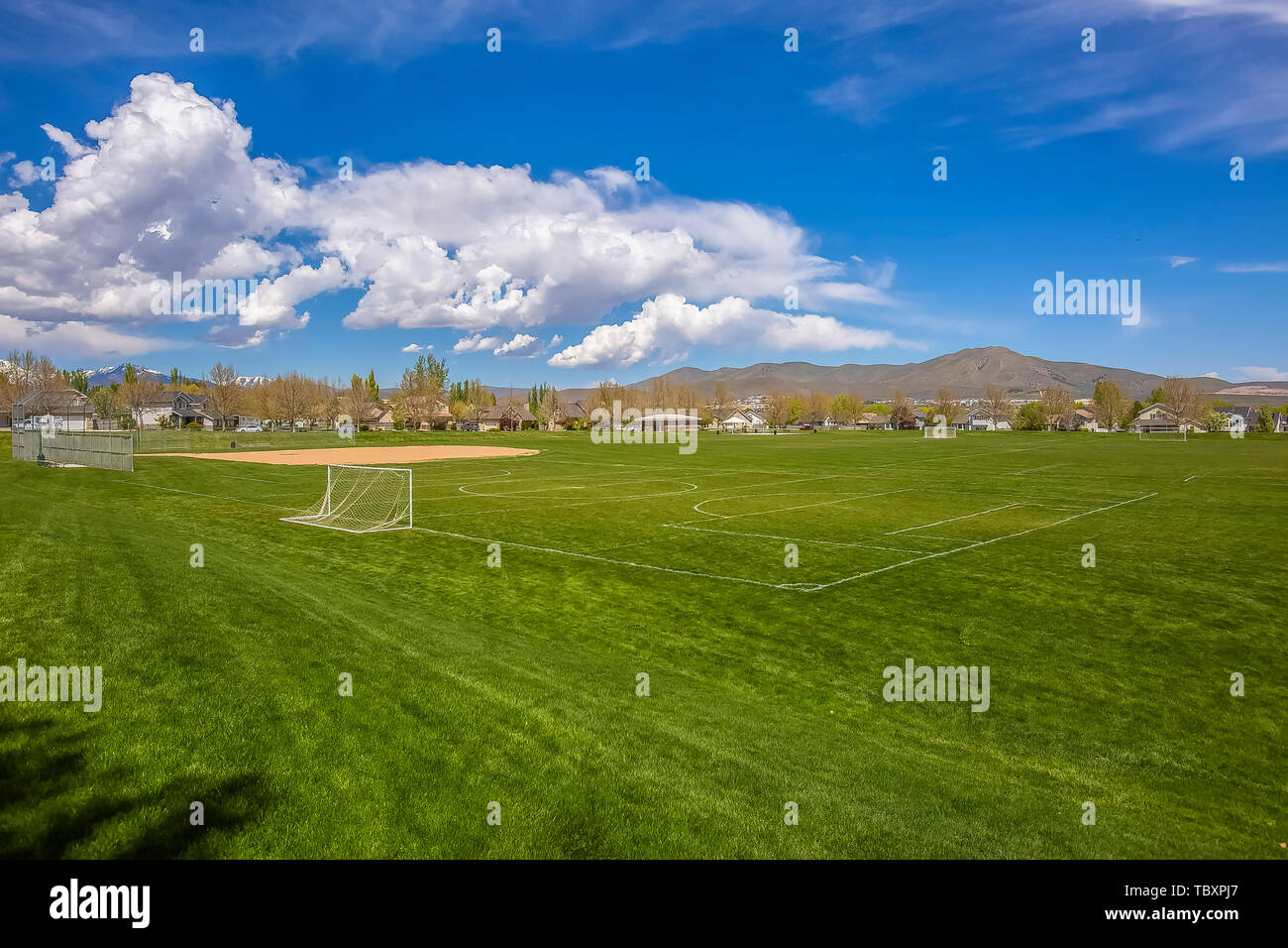 Soccer field and baseball field with view of mountain and cloudy blue ...