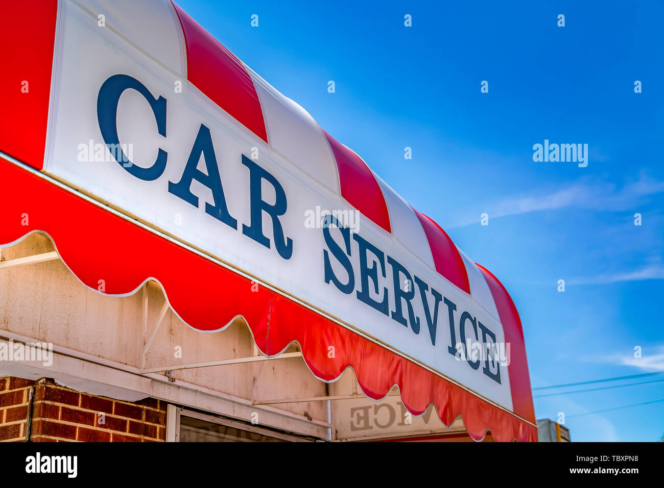 Car Service sign on the curved awning of a commercial brick building ...