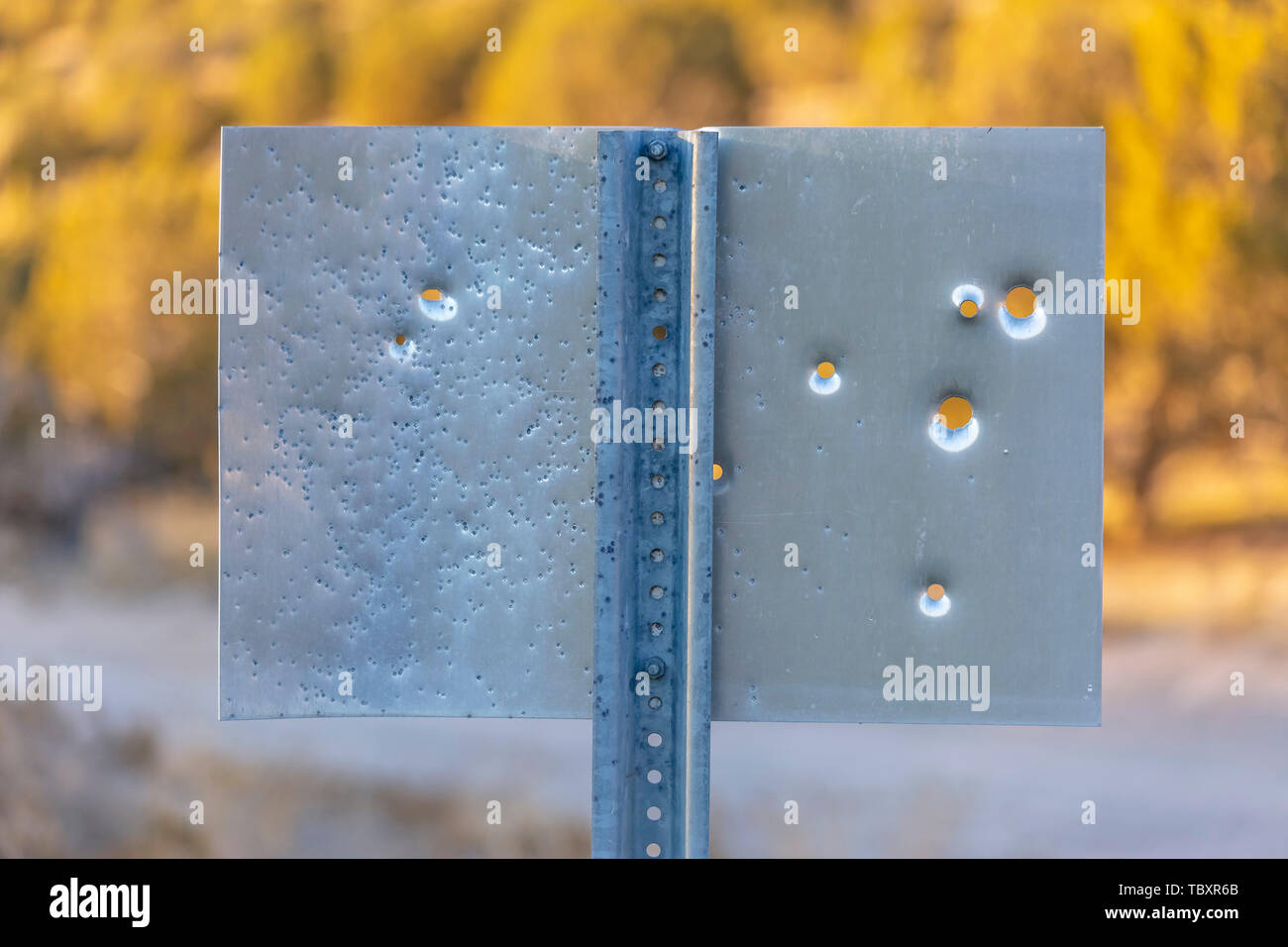 Back view of shiny metal sign board against blurry background on a ...