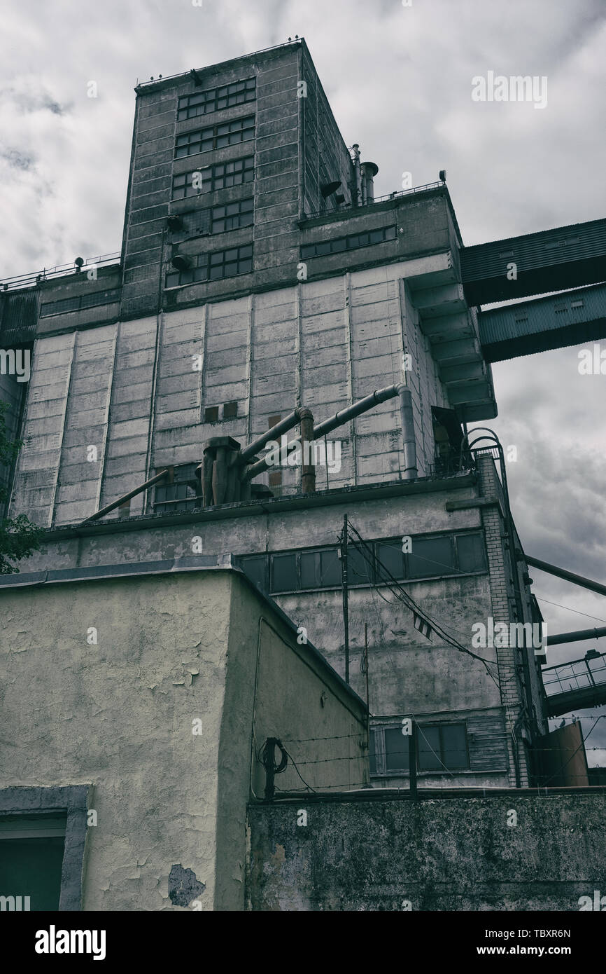 The facade of a huge industrial building with concrete walls and ...