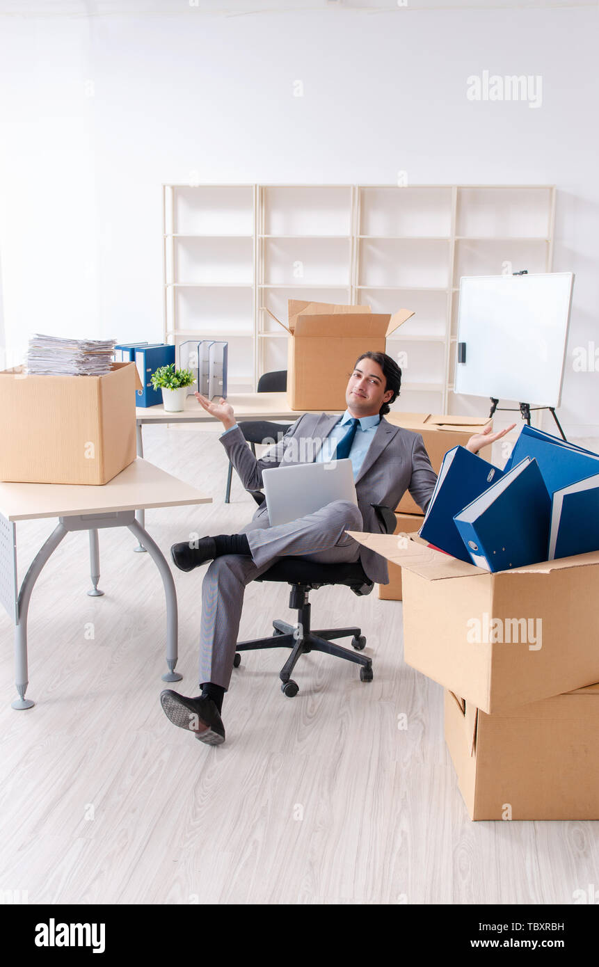 Young man employee with boxes in the office Stock Photo - Alamy
