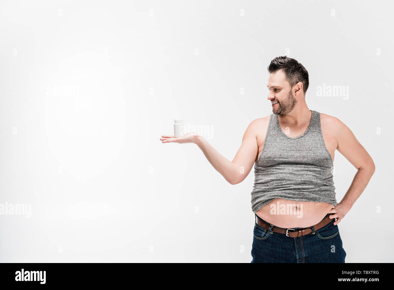 overweight man holding bottle of medicine on white with copy space ...
