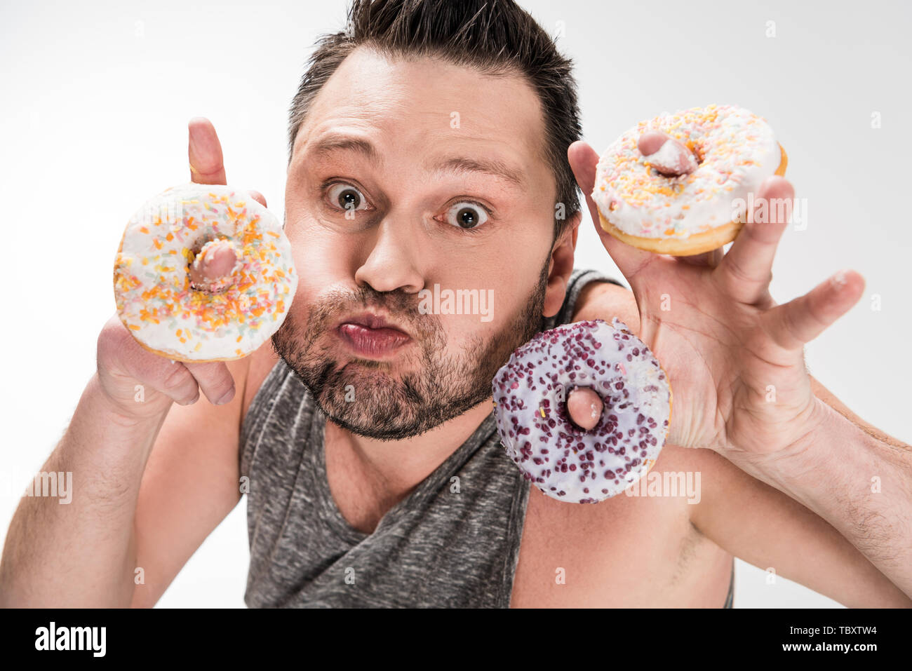 chubby man making face expression and holding donuts isolated on white ...