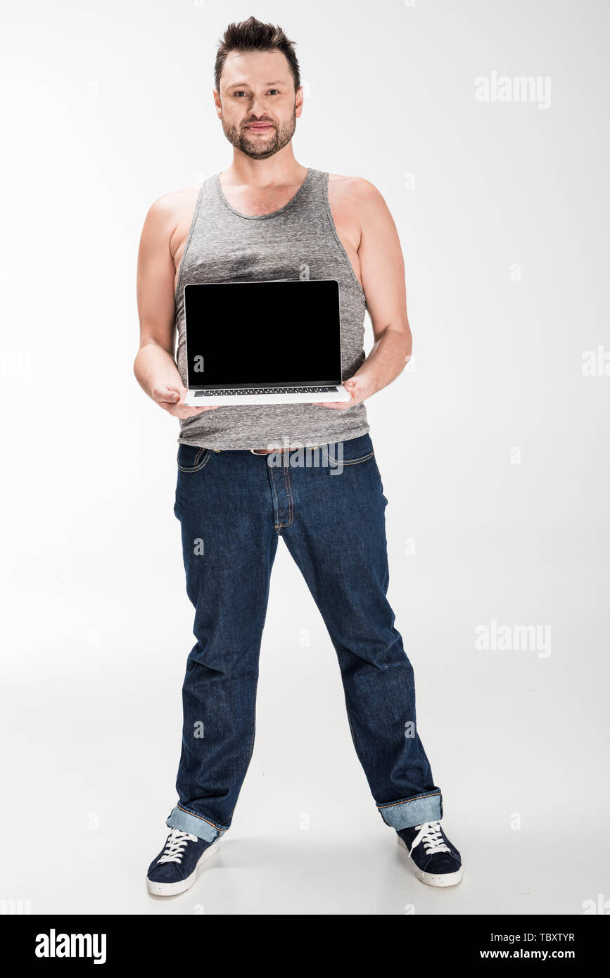 overweight man looking at camera and showing laptop with blank screen ...